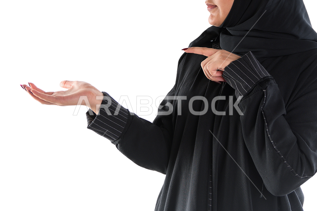 Close-up of a Saudi Arabian Gulf woman wearing an abaya and veil, hand ...