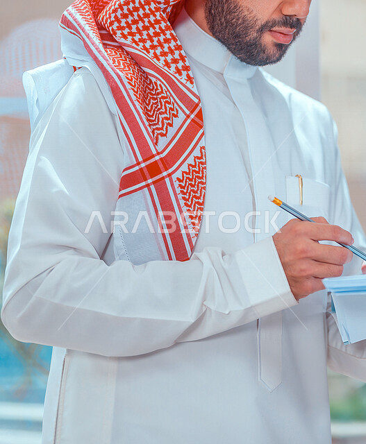 A close-up of a Saudi Arabian Gulf businessman, in traditional Saudi ...