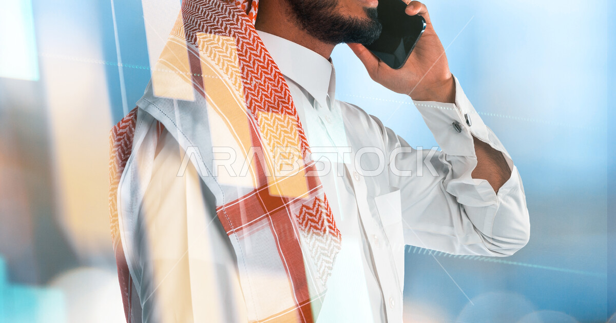 A Saudi Arabian Gulf man wearing a Saudi outfit makes a mobile phone ...