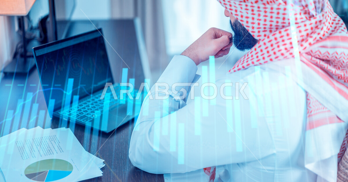 A Saudi Arabian Gulf man using a laptop computer, graphic analytics and ...