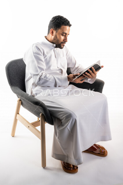 Portrait of a Saudi Arabian Gulf man in Saudi dress sitting on a chair ...
