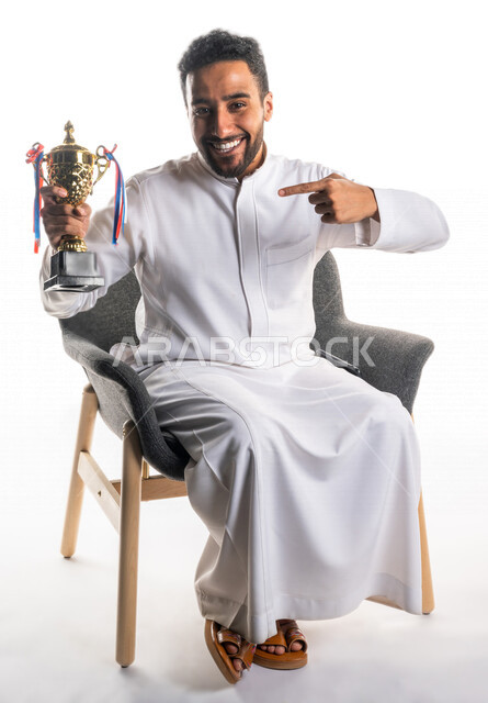 Portrait of a Saudi Arabian Gulf man wearing the Saudi uniform sitting ...