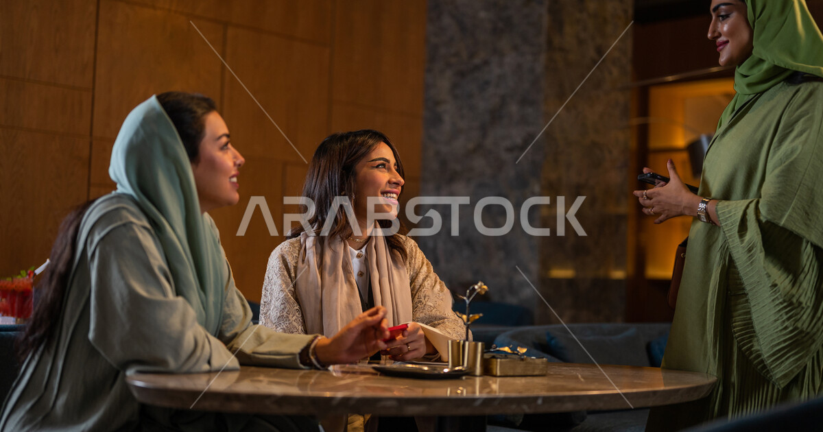 Saudi Arabian Gulf female friends sitting in the cafe, social relations ...