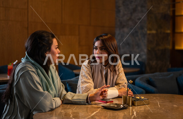 Saudi Arabian Gulf female friends sitting in the cafe, social relations ...