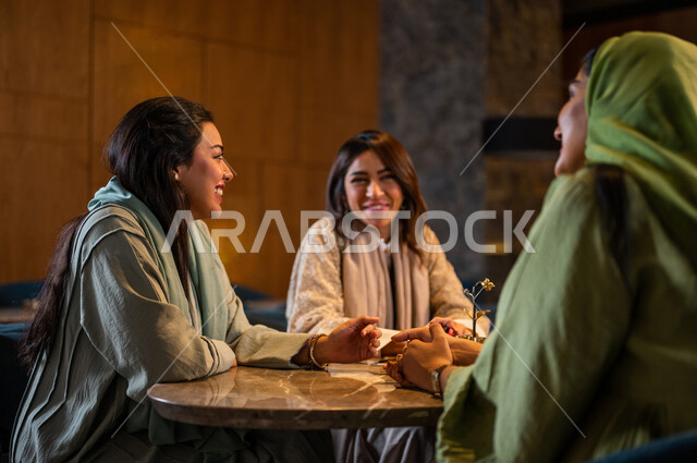 Saudi Arabian Gulf female friends sitting in the café, social relations ...
