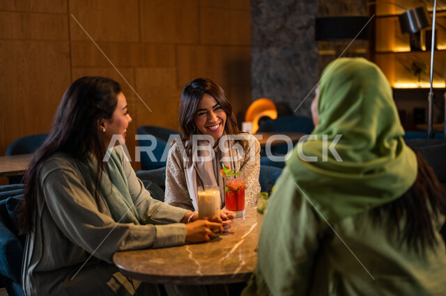 Saudi Arabian Gulf female friends sitting in the café, social relations ...