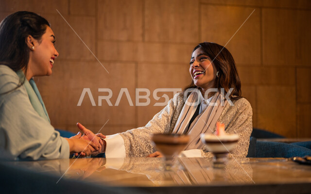 Saudi Arabian Gulf female friends sitting in the café, social relations ...