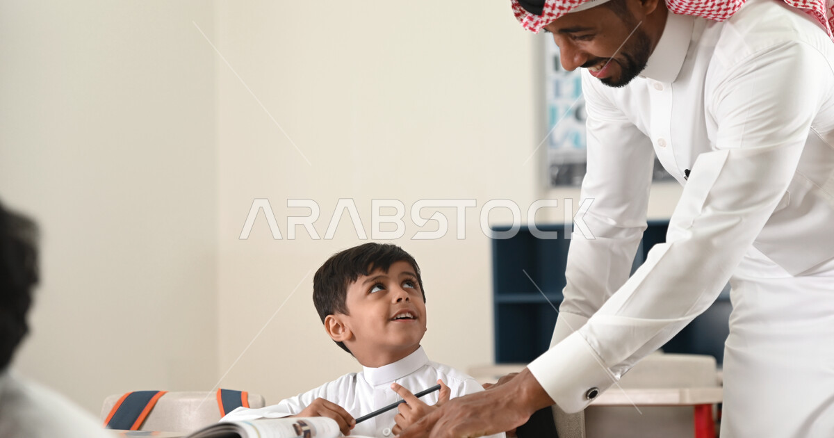 A Saudi Arabian Gulf teacher who helps students to solve questions in ...