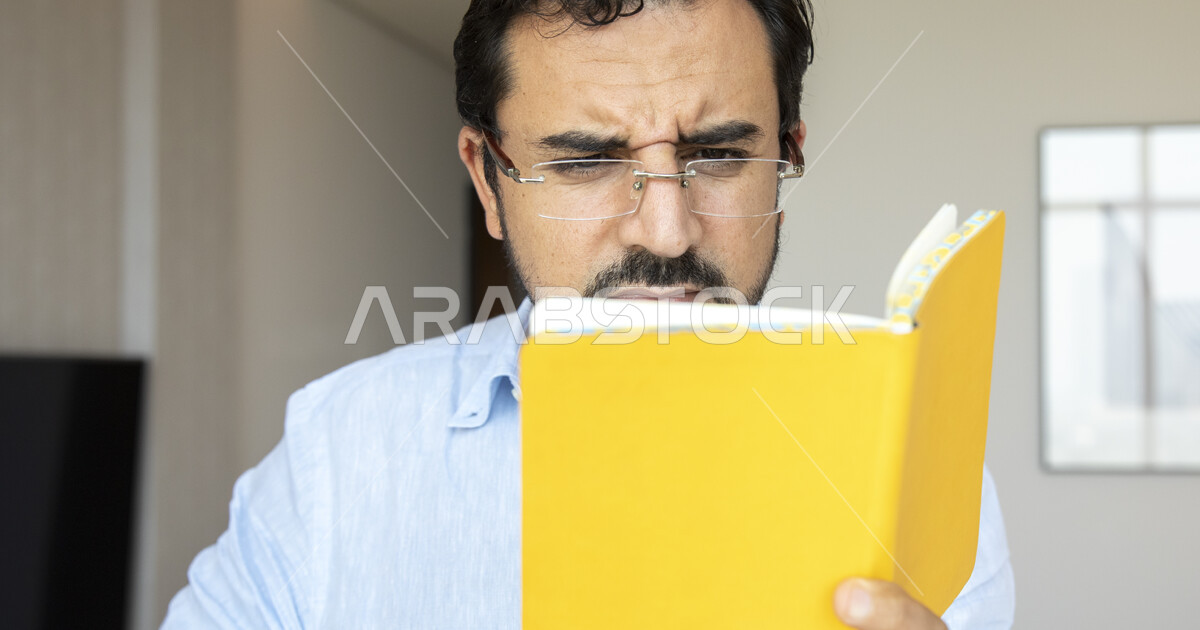 رجل عربي يحمل بيده كتاب ، القراءة والتثقف ، قضاء أوقات الفراغ بالقراءة ...