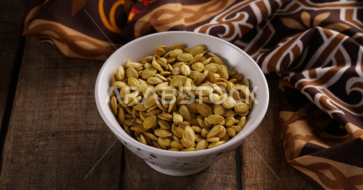 A plate of roasted and salted watermelon seeds, salty nuts, cloves ...