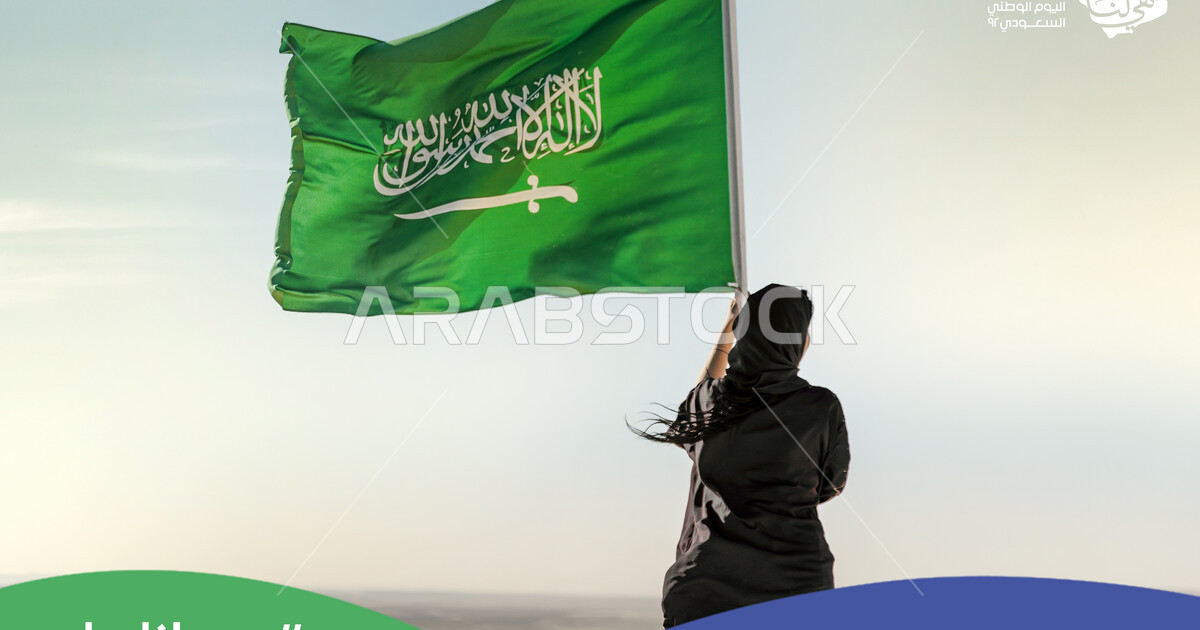 Angle from the back of a Saudi Arabian Gulf woman holding the flag of ...