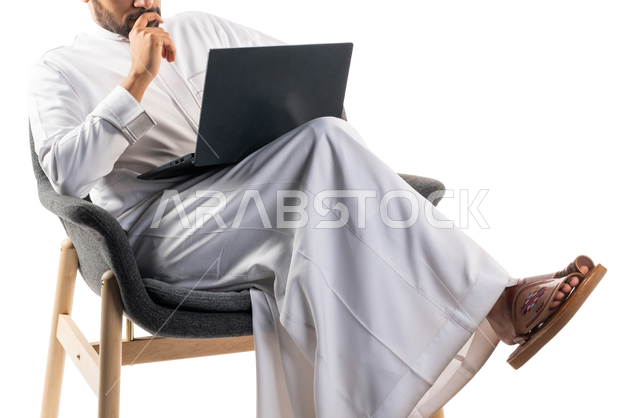 Portrait of a Saudi Arabian Gulf man sitting on a chair holding a ...