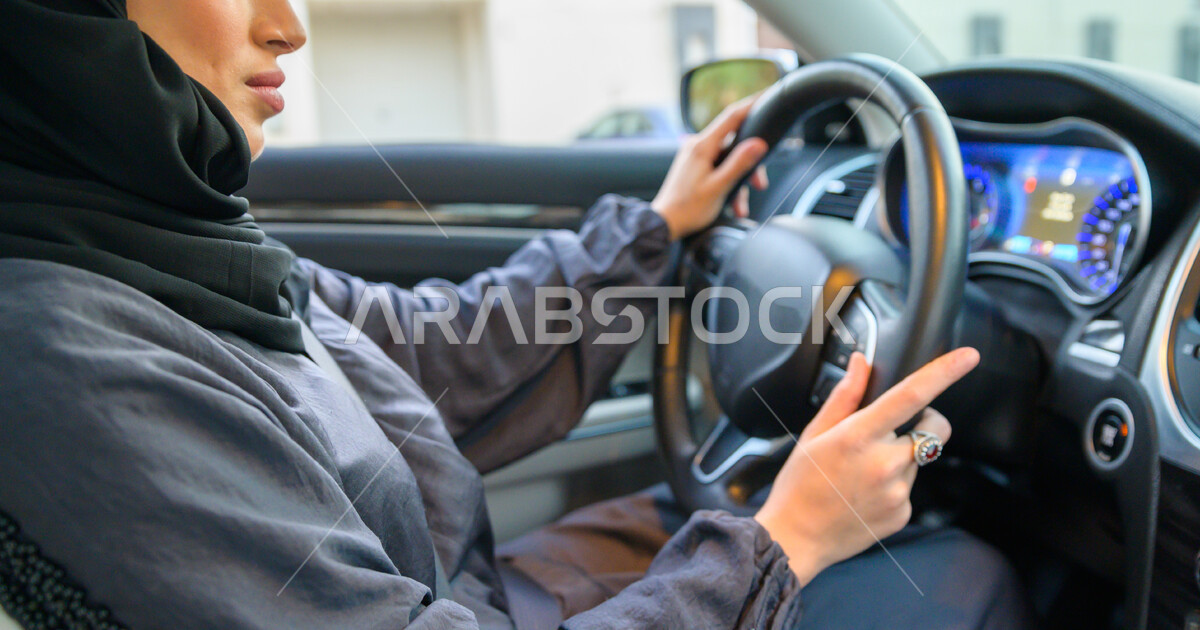 A Saudi Arabian Gulf woman driving in Saudi Arabia, wearing a Gulf ...