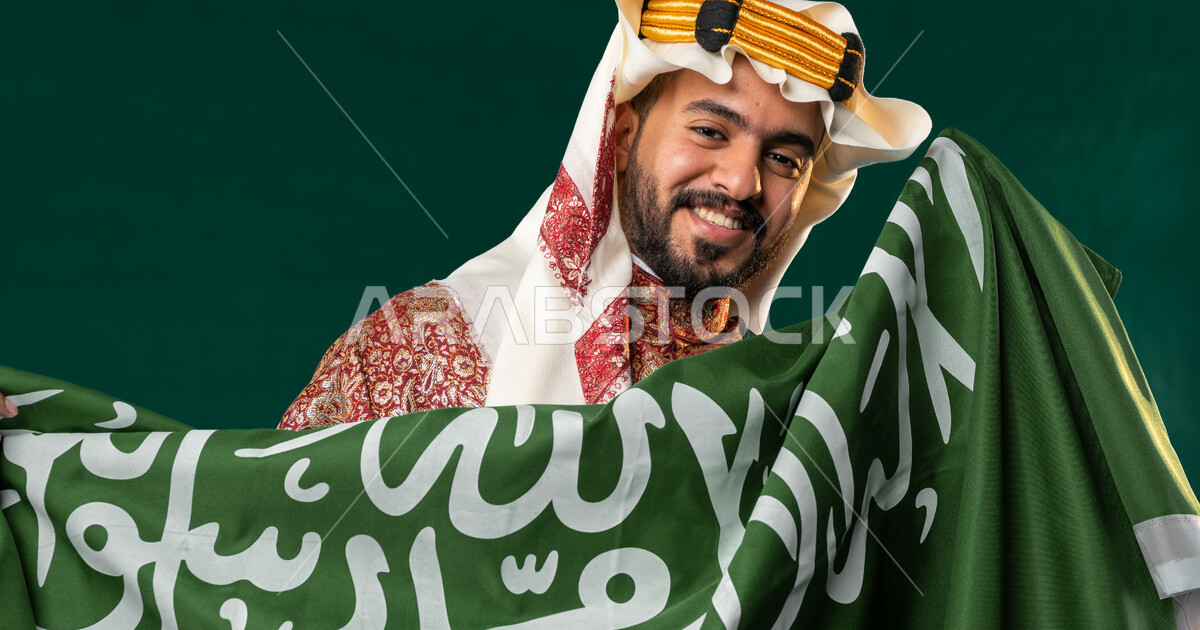 A chroma of a Saudi Arabian Gulf man, carrying the Saudi flag, wearing ...