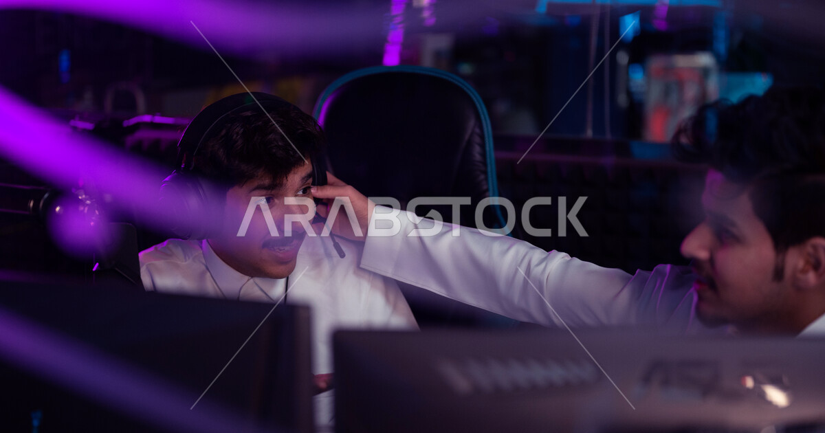 Two young Saudi Arabian Gulf teenagers in an electronic game store, a ...