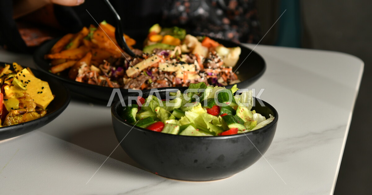 Close-up of the hand of a Saudi Arabian Gulf woman eating, a delicious ...