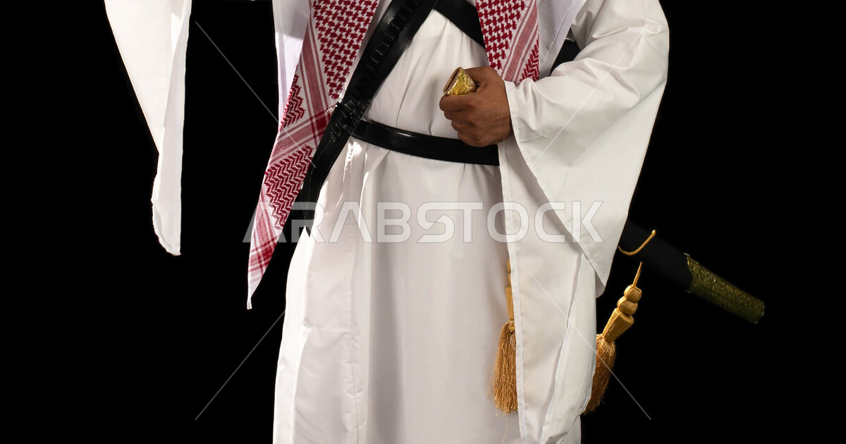 A Saudi Arabian Gulf man, holding a long sword in his hand, wearing the ...