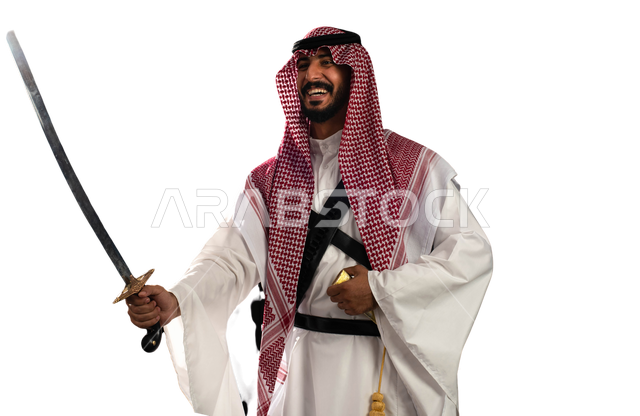 A Saudi Arabian Gulf man, holding a long sword in his hand, wears the ...