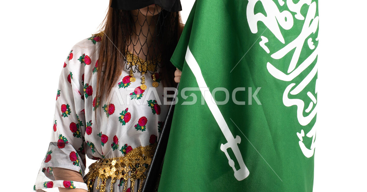 Portrait of a Saudi Arabian Gulf woman raising the Saudi flag, wearing ...