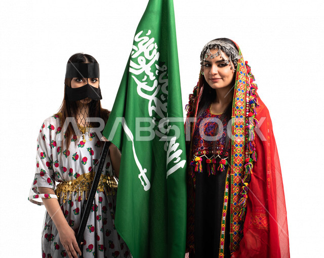 Portrait of two Gulf Saudi Arabian women raising the flag of Saudi ...