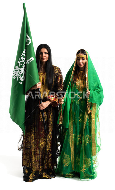 Portrait of two Gulf Saudi Arabian women raising the flag of Saudi ...