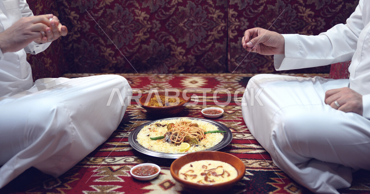 Two young Saudi Arabian Gulf men gathered at the dining table, Ramadan ...