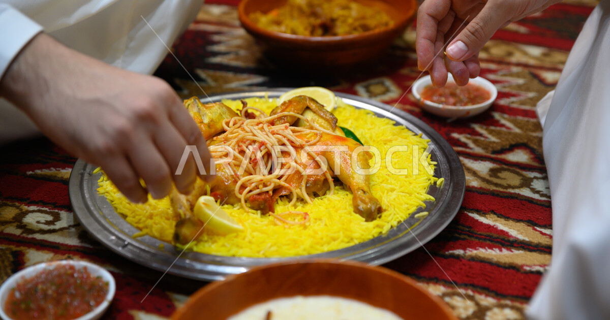 Two young Saudi Arabian Gulf men gathered at the dining table, Ramadan ...