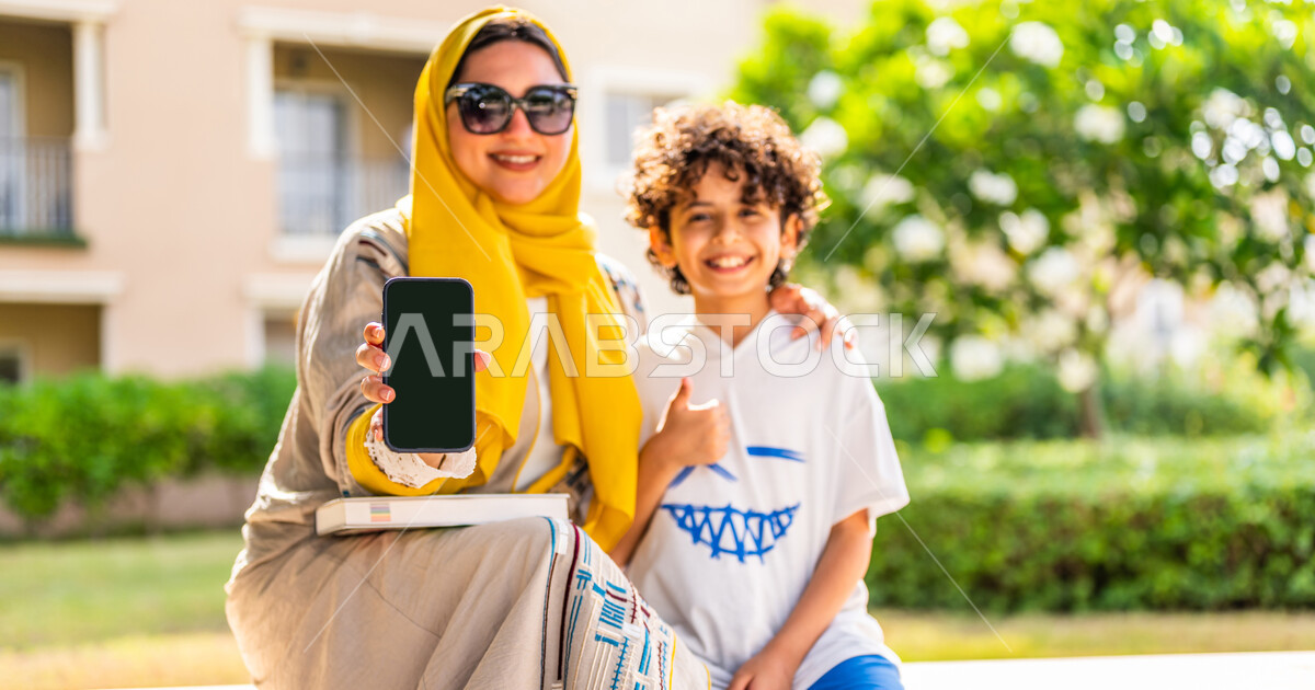 مرأة عربية خليجية سعودية مع ابنها تقضي أوقات ممتعة في الأحياء السكنية ...