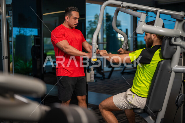 A Saudi Arabian Gulf youth wearing sports clothes in the gym with a ...