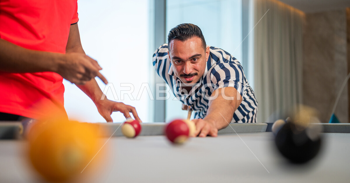 A group of Saudi Arabian Gulf youths wearing casual clothes, playing ...