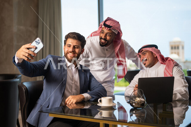 A Saudi Arabian Gulf business team with a foreign businessman wearing a ...
