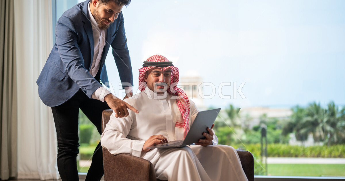 A Saudi Arabian Gulf businessman with an Arab businessman wearing a ...
