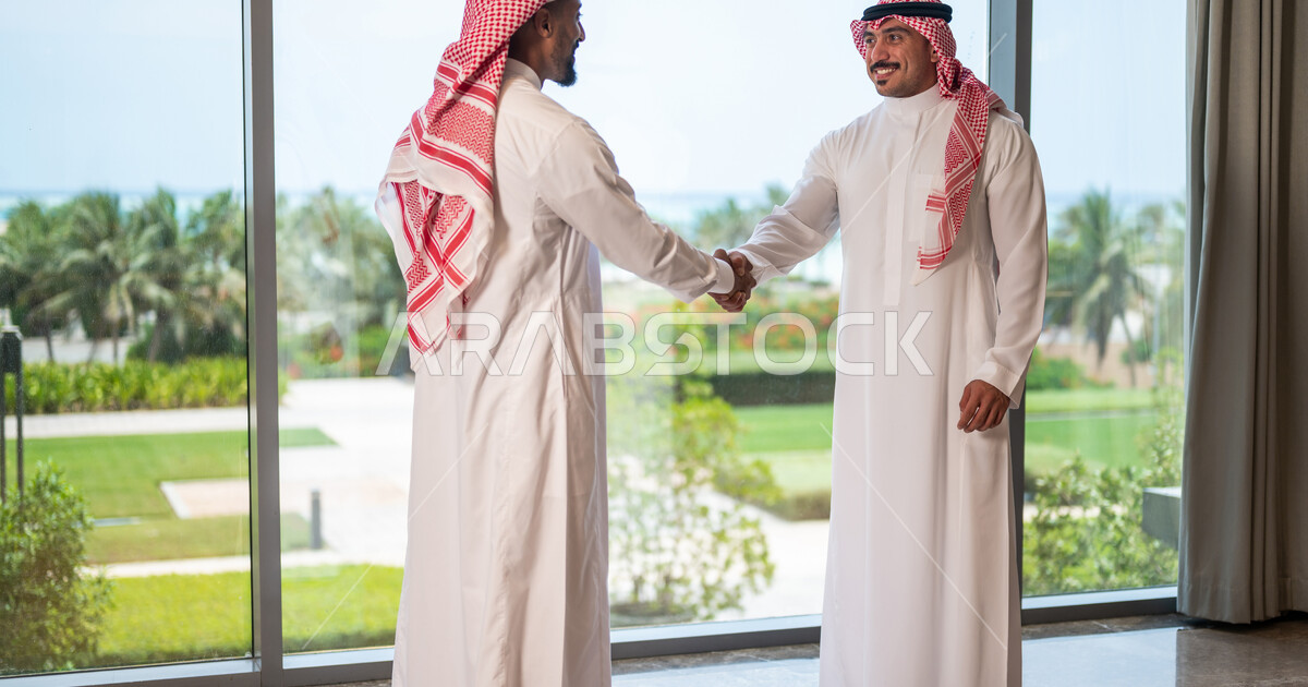 Two Saudi Arabian Gulf businessmen shake hands, agreement and ...