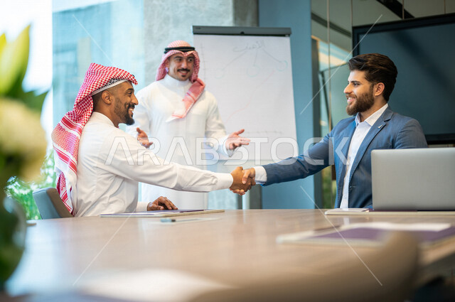 A Saudi Arabian Gulf businessman shakes hands with a businessman ...