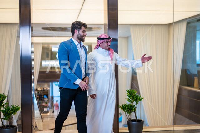 A Saudi Arabian Gulf businessman with an Arab businessman wearing a ...