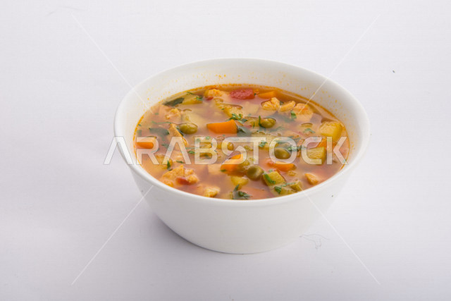 A plate of mixed vegetable soup with chicken, edam vegetable broth ...