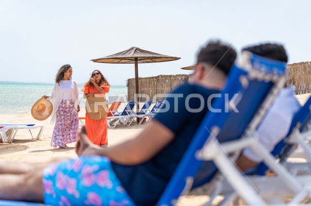 A group of friends meeting on the beach of the Jeddah sea, getting ...