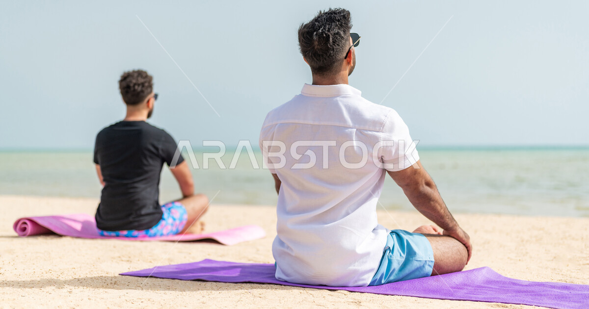 A picture from the back of two Saudi Arabian Gulf youths practicing ...