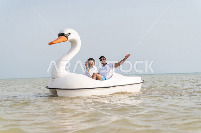 A Saudi Arabian Gulf couple enjoying a goose-shaped water pedal ...