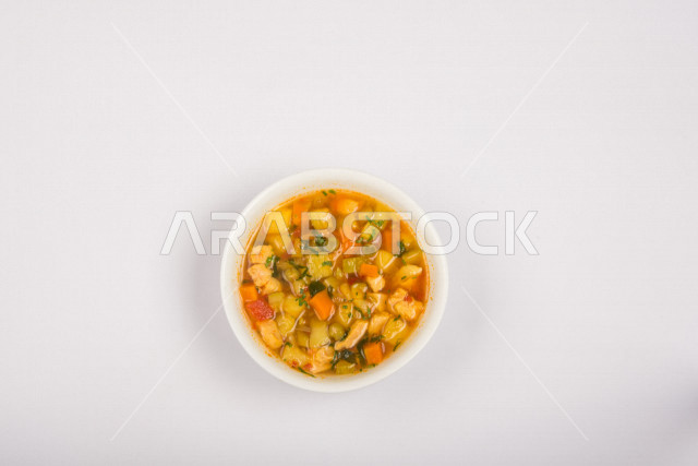 A plate of mixed vegetable soup with chicken, edam vegetable broth ...