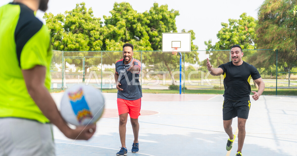 A team of Saudi Arab Gulf friends playing football, playing football in ...