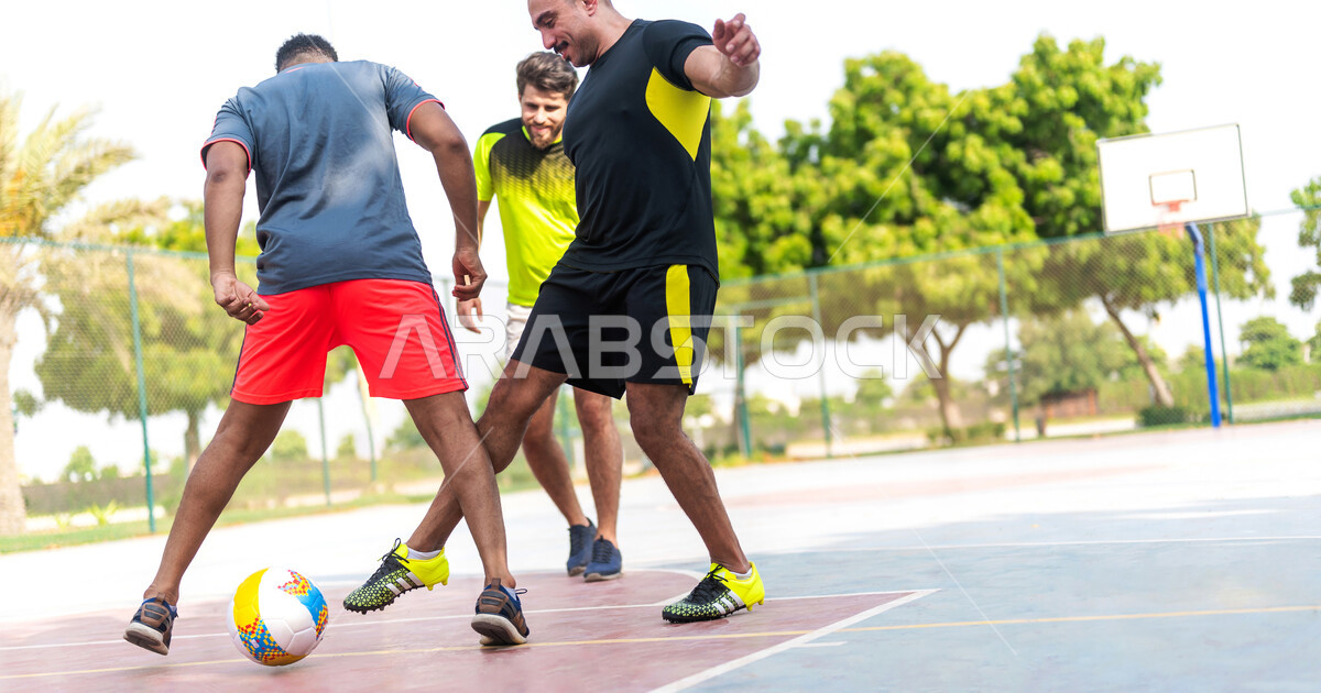 A team of Saudi Arab Gulf friends playing football, playing football in ...