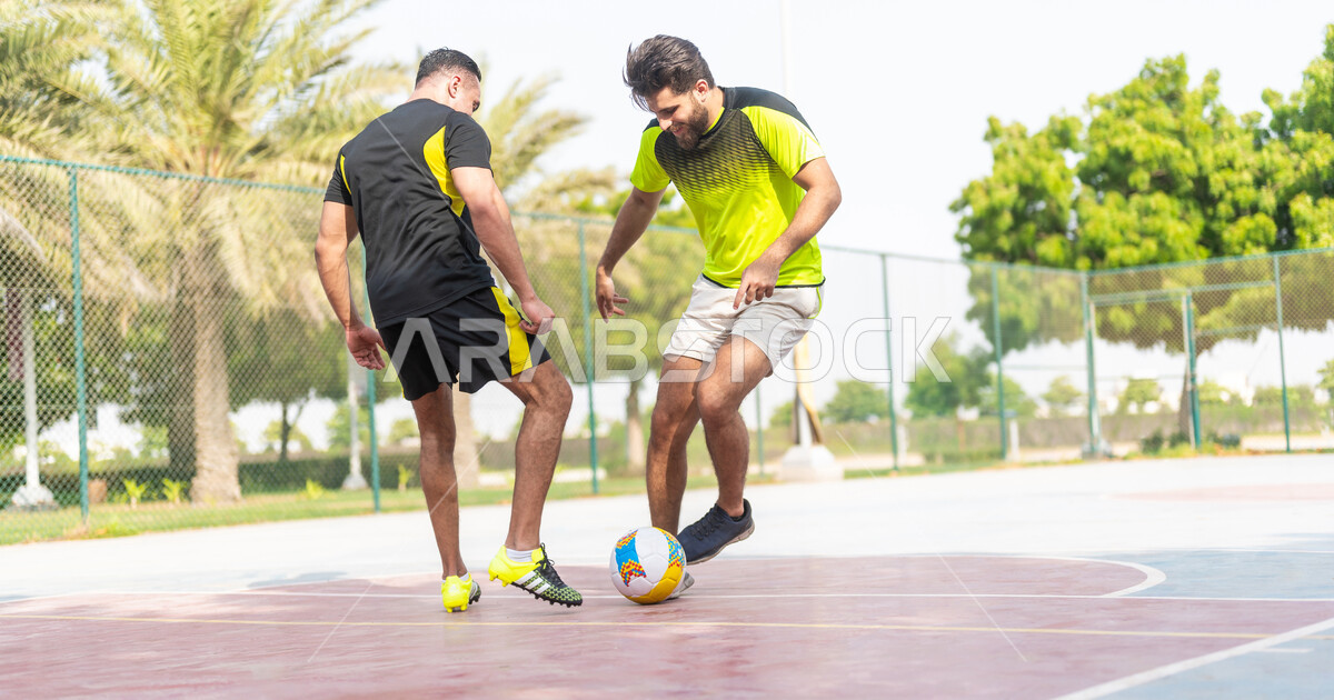 A team of Saudi Arab Gulf friends playing football, playing football in ...