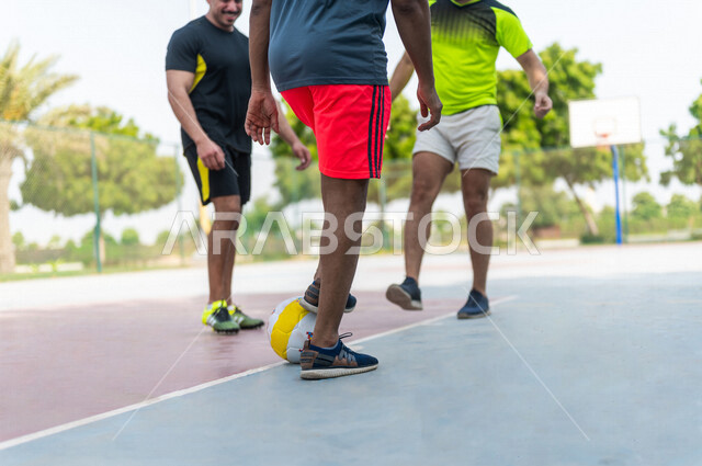 A team of Saudi Arab Gulf friends playing football, playing football in ...