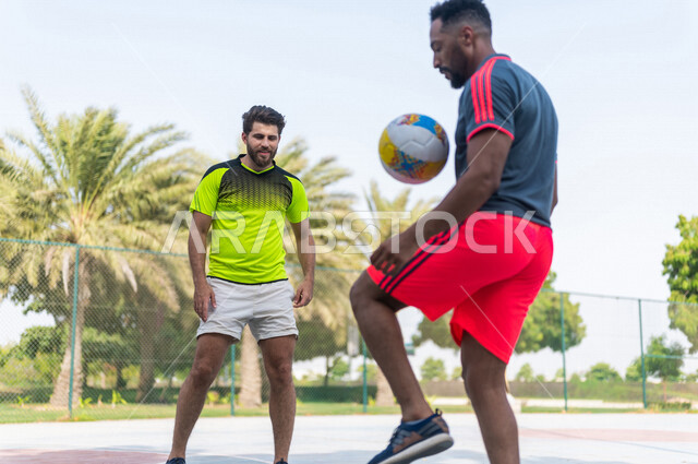 A team of Saudi Arab Gulf friends playing football, playing football in ...