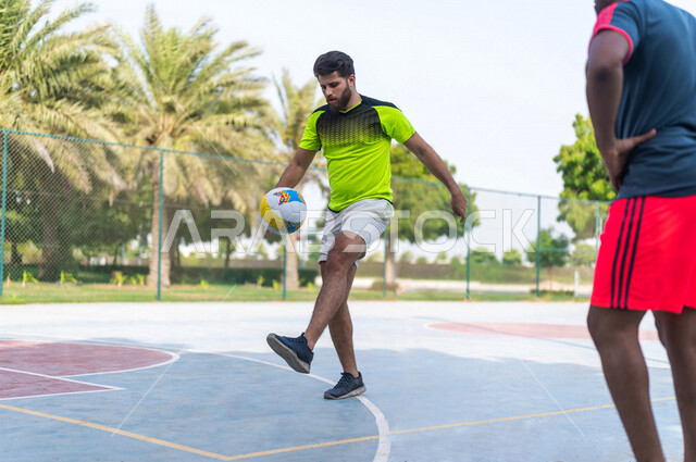 A team of Saudi Arab Gulf friends playing football, playing football in ...