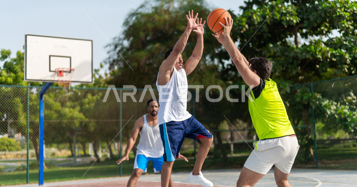 A team of Saudi Arabian Gulf friends playing basketball, practicing ...