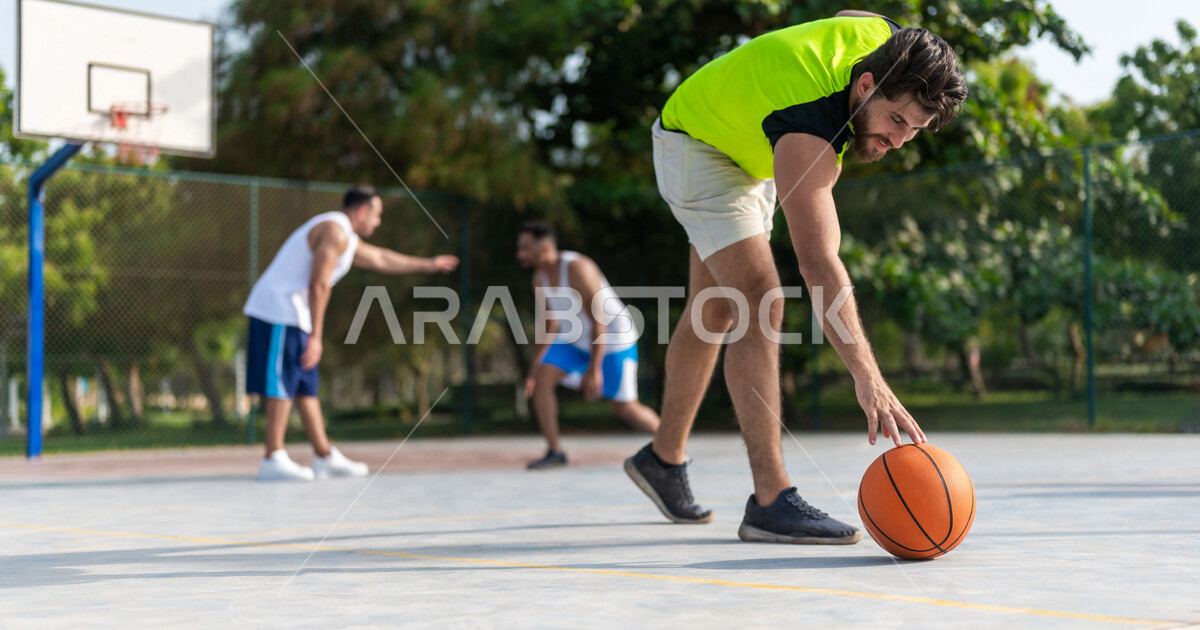 A team of Saudi Arabian Gulf friends playing basketball, practicing ...