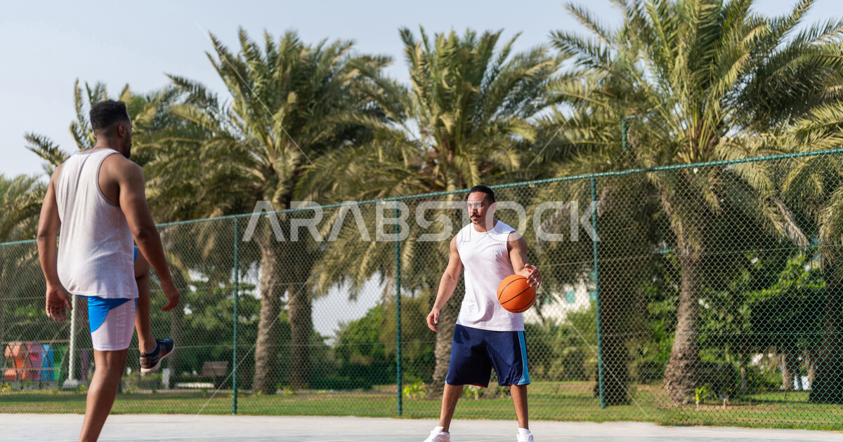 A team of Saudi Arabian Gulf friends playing basketball, practicing ...