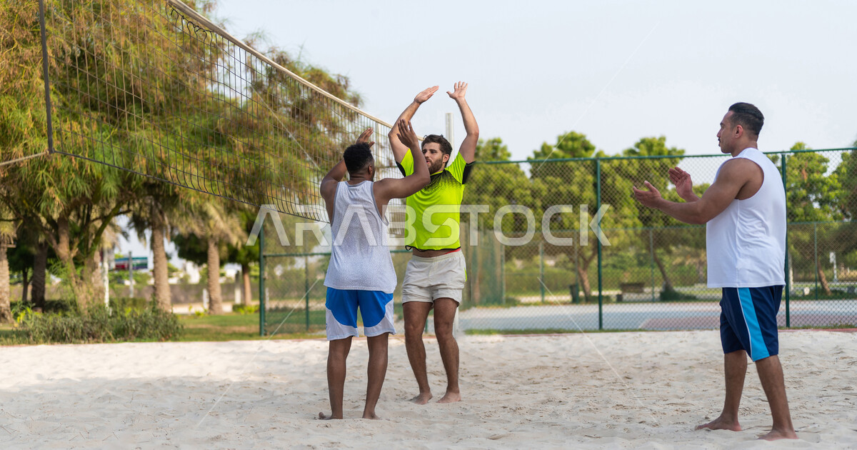 A team of Saudi Arabian Gulf friends playing volleyball, celebration of ...